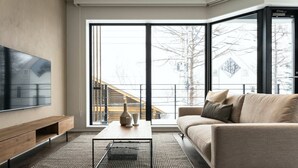 Uma sala de estar moderna com uma janela grande, um sofá, uma mesa de centro e uma TV na parede.