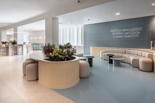 Uma área de recepção moderna com balcão curvo, assentos e uma parede inspiradora.
