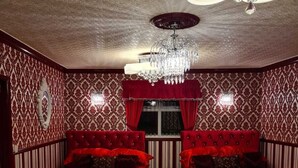 Quarto com duas camas, um candelabro e papel de parede estampado.