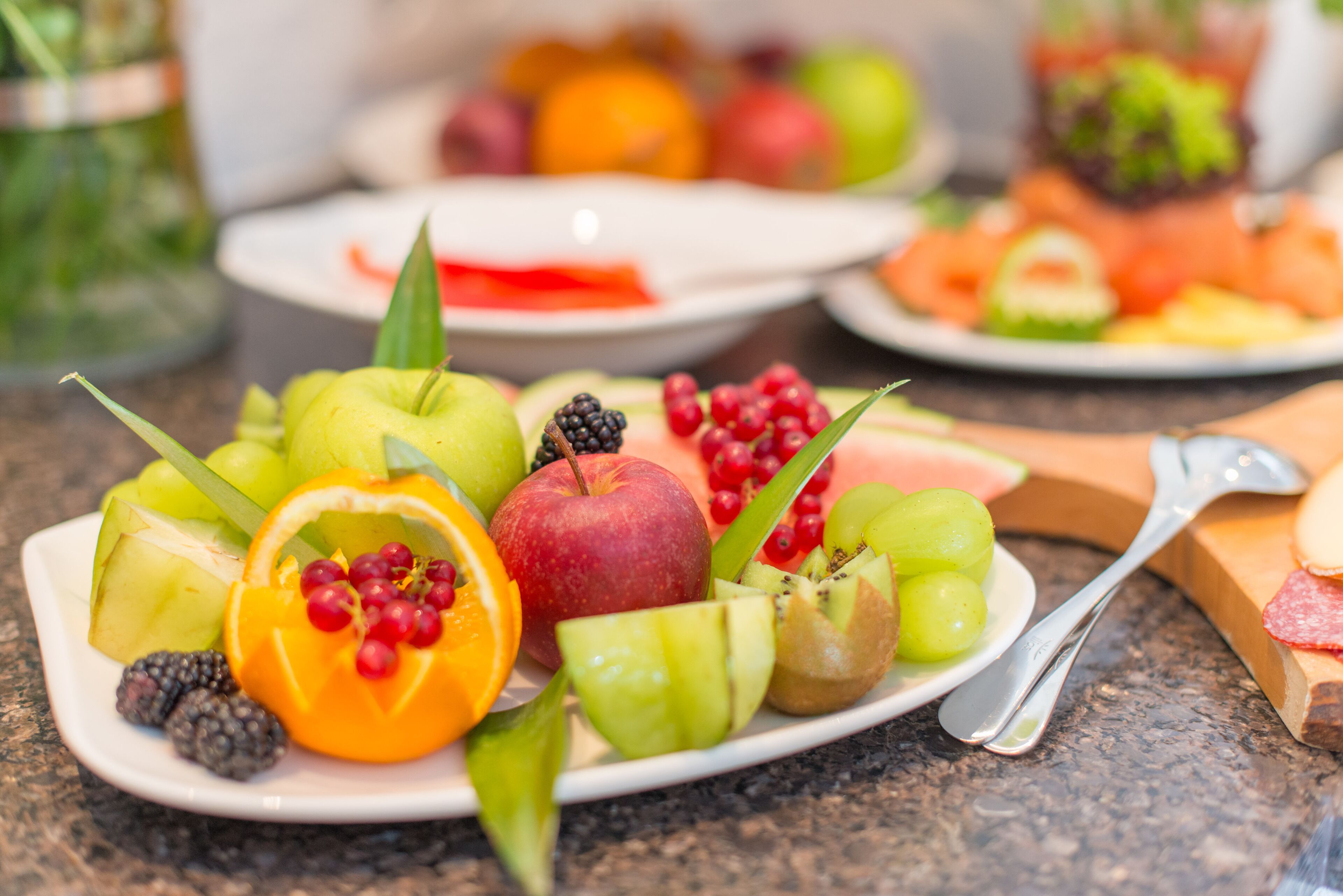 Um prato com frutas variadas, incluindo maçãs, laranjas e frutos silvestres.