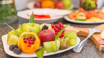 Um prato com frutas variadas, incluindo maçãs, laranjas e frutos silvestres.