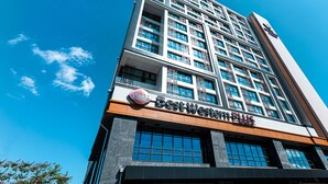 Um edifício alto de hotel com uma placa chamativa 'Best Western PLUS' na fachada.