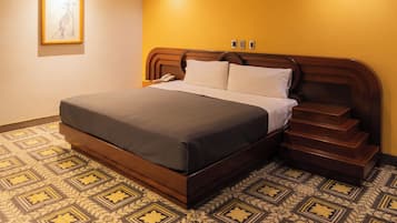 Uma cama bem arrumada com cabeceira de madeira, piso estampado e um quadro na parede.
