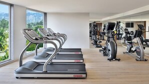 Academia moderna com esteiras, elípticos e equipamentos de musculação.