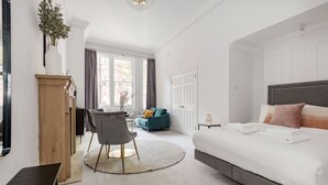 Quarto com cama, escrivaninha, cadeira, janela e porta.