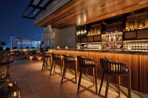 Uma área de bar com mobiliário de madeira e balcão bem iluminado.