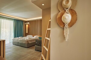 Quarto de hotel moderno com uma cama, área de estar e um objeto decorativo na parede.