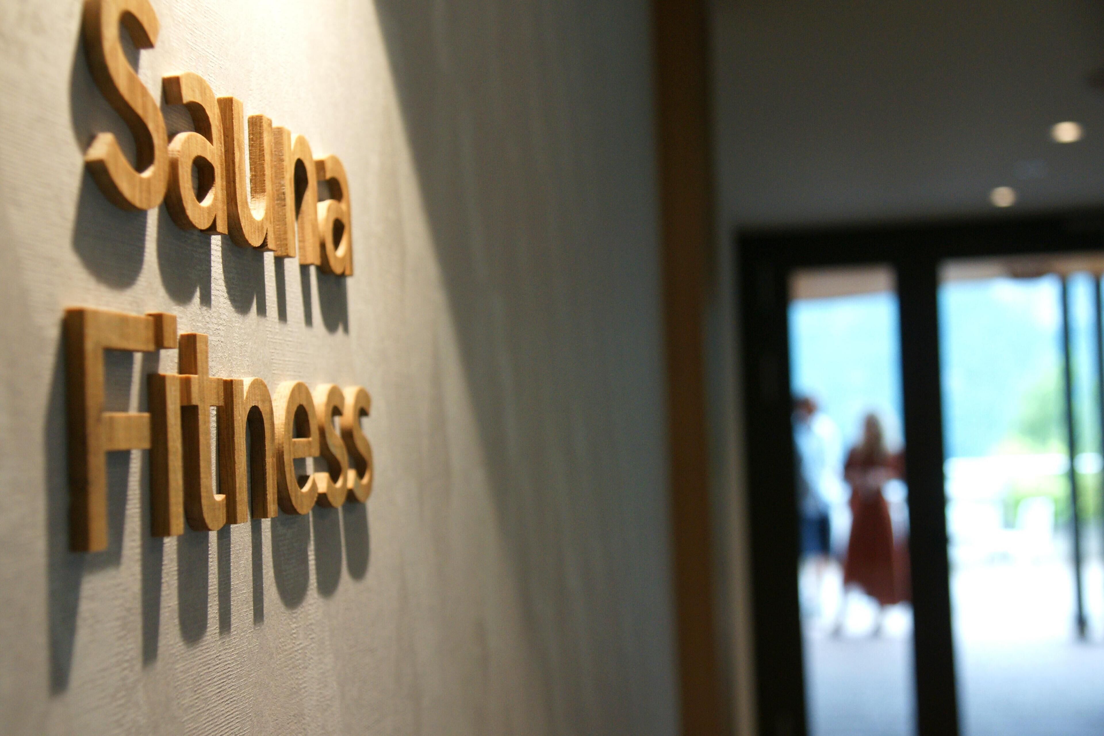 Pareda com as palavras "Saluna Fitness" em letras de madeira.
