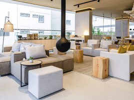 Uma sala de estar moderna com um conjunto de sofá, uma mesa de centro e um lustre grande.