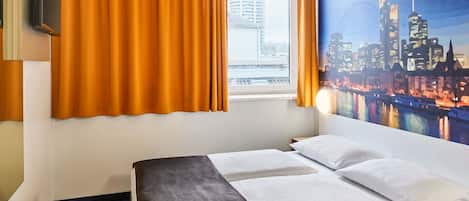 Quarto de hotel com cama, janela com cortinas, pintura de paisagem urbana e televisão de tela plana na parede.
