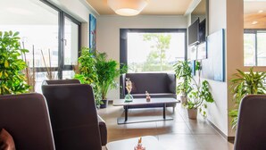 Uma área de estar moderna com sofás de couro, uma mesa de centro e plantas em vasos.