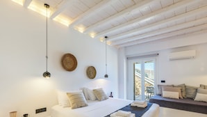 Quarto moderno com uma cama grande, um sofá menor e uma varanda com vista.
