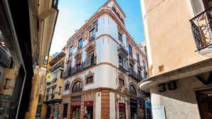 Um edifício histórico com arquitetura ornamentada, fachada visível e uma placa indicando o endereço.