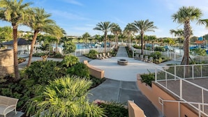 Resort com área de piscina, palmeiras e lareira.
