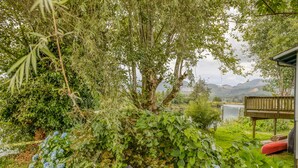 Um deck de madeira com vista para um lago e montanhas.