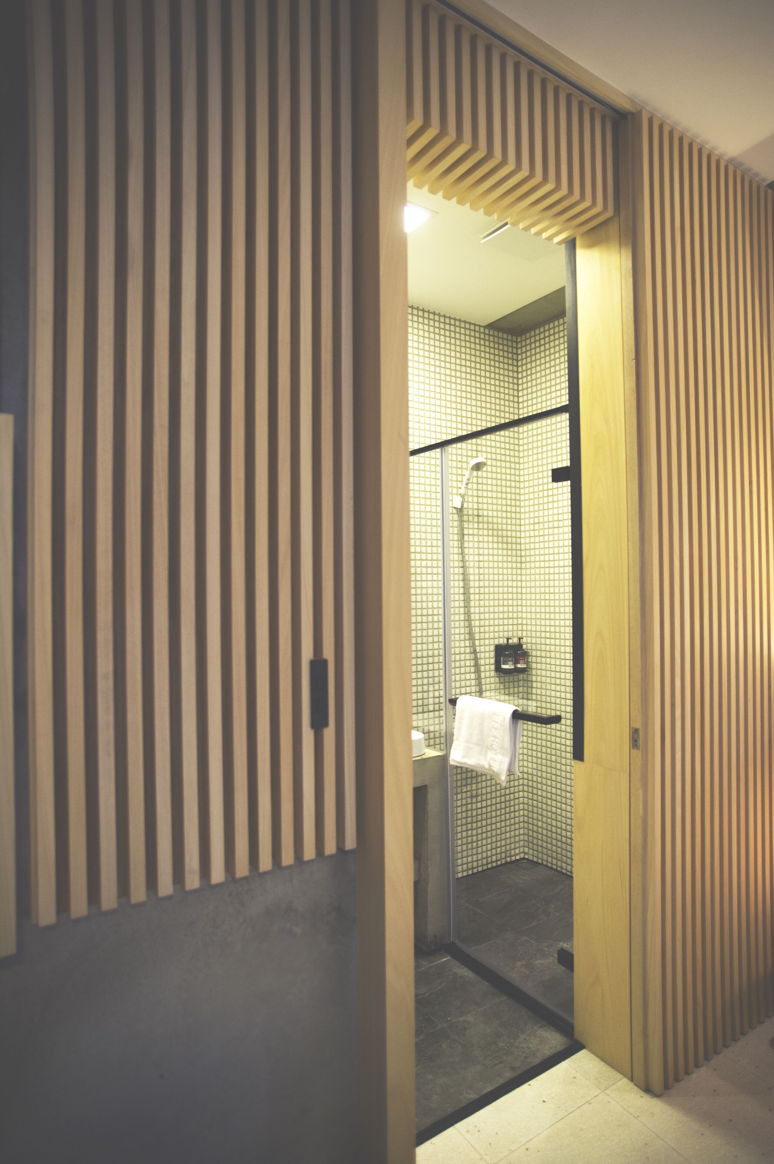 Uma casa de banho moderna com chuveiro, um porta-toalhas e um sanita à vista.