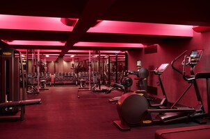 Uma academia com diversos equipamentos de exercício, incluindo esteiras, elípticos e aparelhos de musculação.