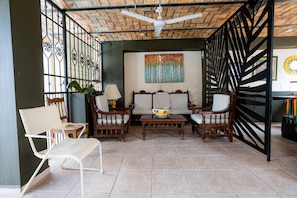 Sala de estar com ventilador de teto, um quadro e um sofá.