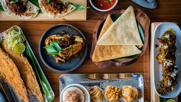 Diversos pratos, incluindo tacos, uma tigela de sopa e um prato de peixe frito.