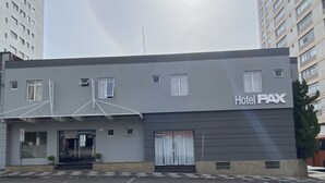 Um edifício moderno de hotel com uma placa na fachada que diz 'Hotel FAX'.