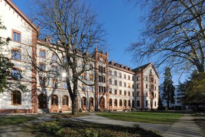 Um edifício histórico com várias arcadas e uma torre do relógio central.