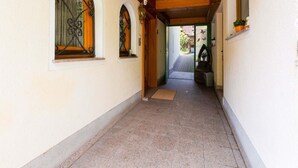 Um corredor com janelas arqueadas e teto de madeira.