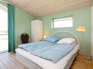 Quarto com cama, guarda-roupa, janela e abajur.