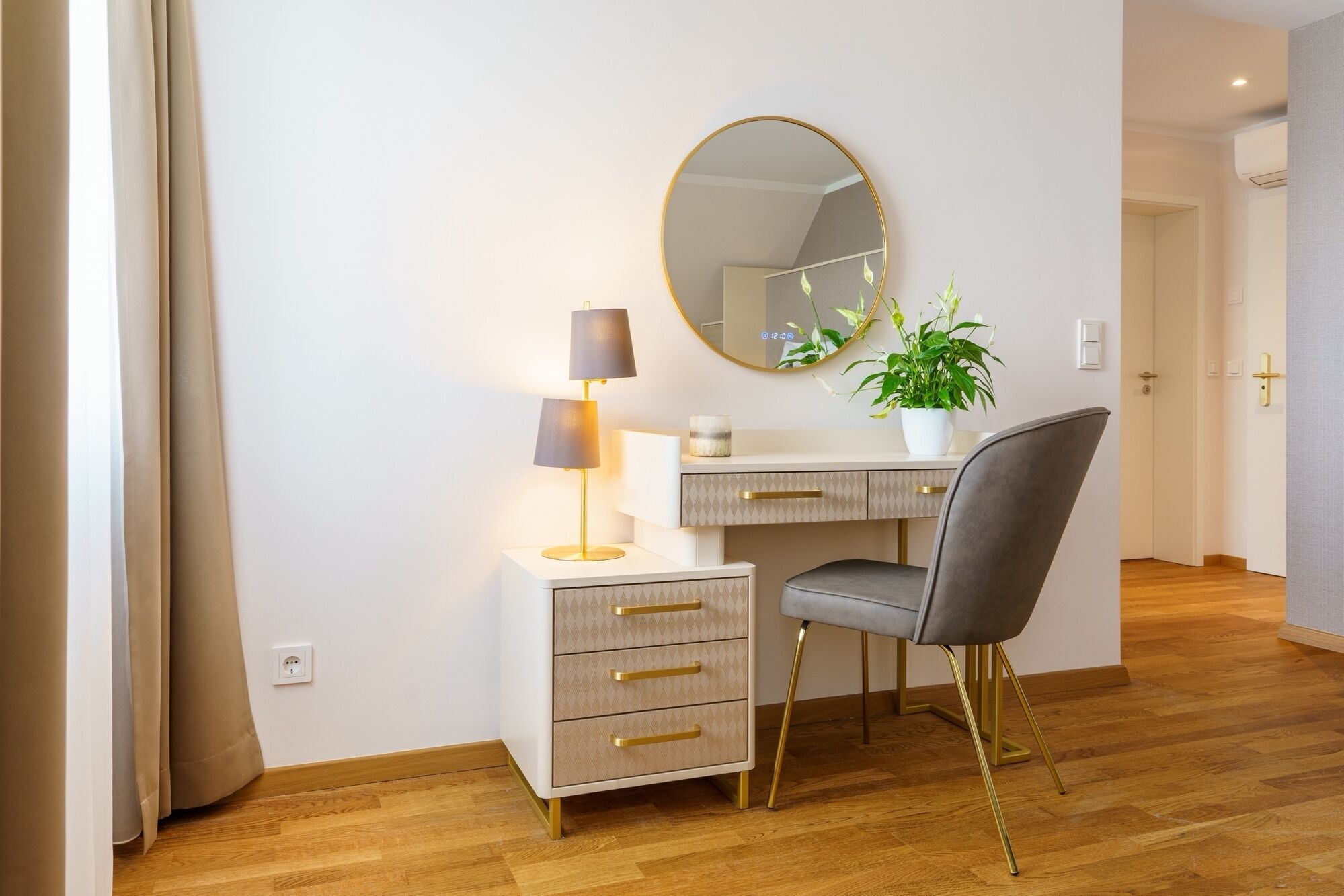 Quarto moderno com cama, mesa de cabeceira, abajur e uma planta em vaso.