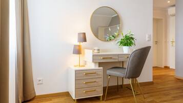 Quarto moderno com cama, mesa de cabeceira, abajur e uma planta em vaso.
