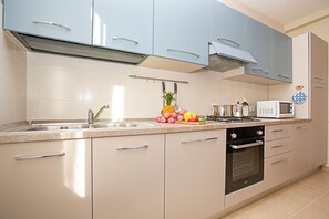 Apartamento Familiar, 2 quartos (Villa Mimosa Appartamento 5) | Cozinha privada | Um frigorífico, um micro-ondas, um forno, uma placa de cozinha