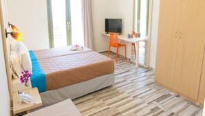 Quarto de hotel com uma cama, uma mesa, uma televisão e um guarda-roupa.