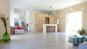Um hall amplo com balcão de recepção, escada e área de estar.