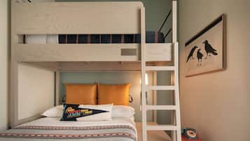 Uma cama beliche com escada, um travesseiro com texto e um quadro na parede.