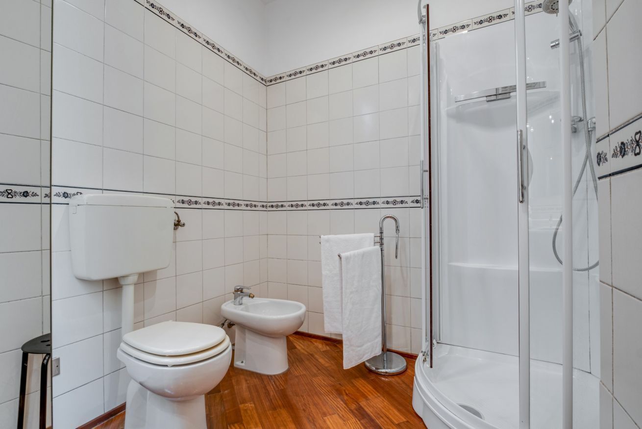Casa de banho moderna com sanita, bidé e cabine de duche.