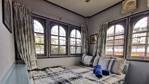 Quarto com cama, cortinas e janelas.