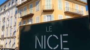 Um edifício com varandas e uma placa com a inscrição "LE NICE ETOILE".