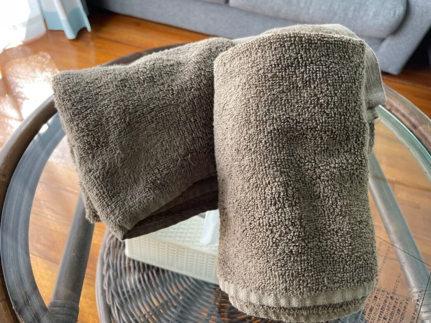 Um par de toalhas dobradas sobre uma mesa de vidro.