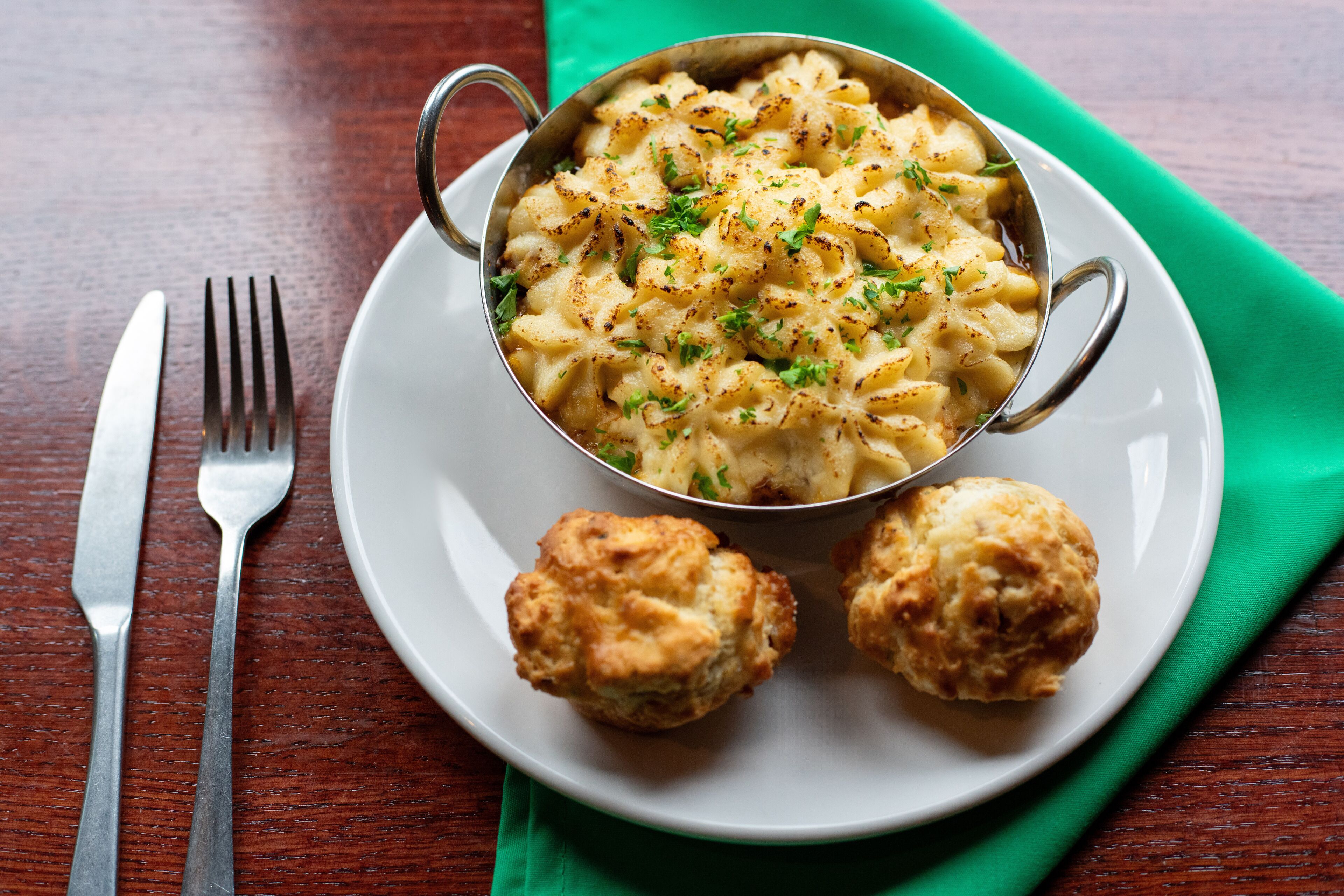 Uma tigela de macarrão com queijo e biscoitos num prato.