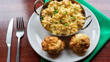 Uma tigela de macarrão com queijo e biscoitos num prato.