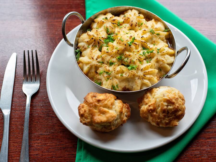 Uma tigela de macarrão com queijo e biscoitos num prato.