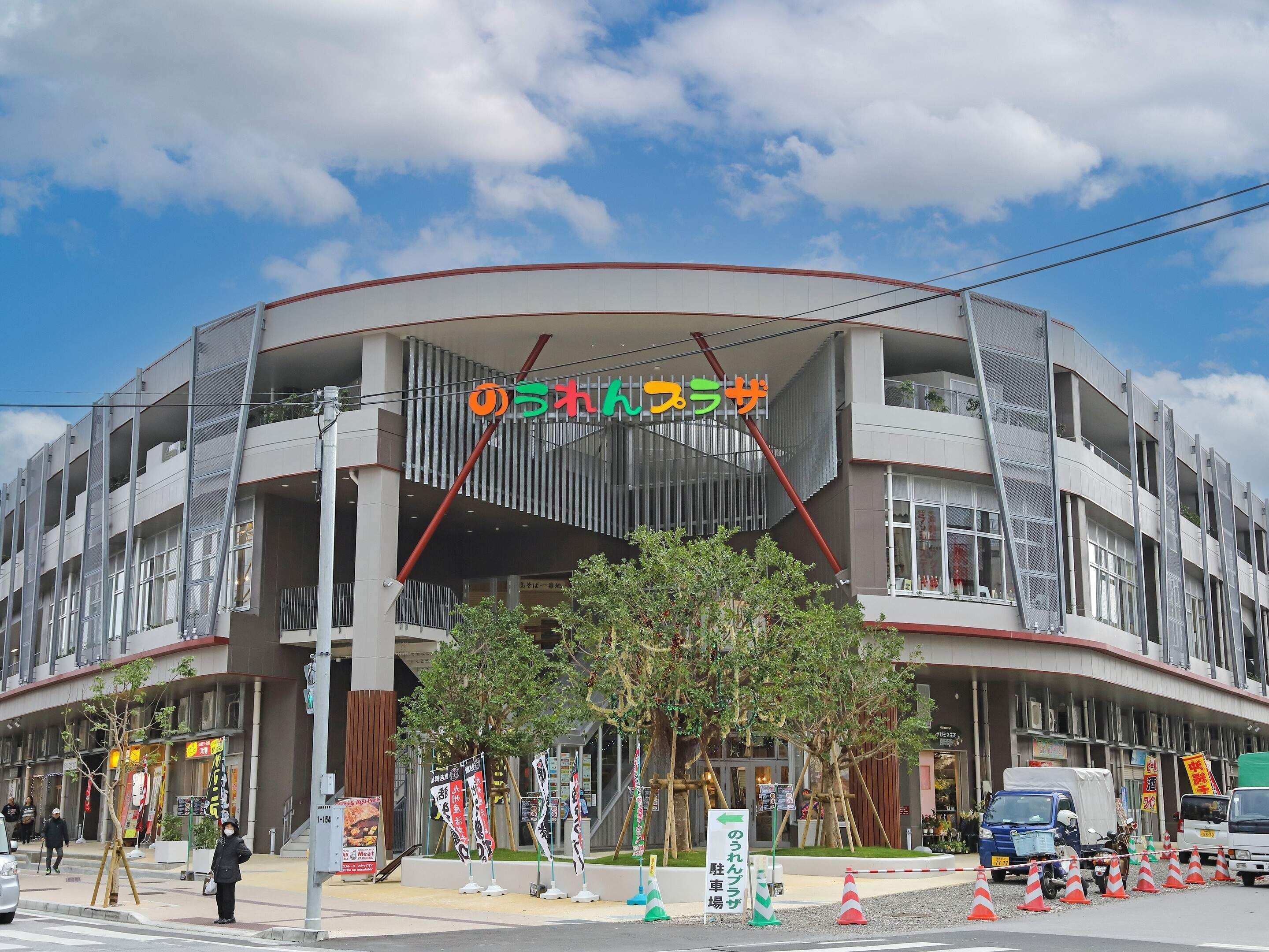 Um edifício moderno com fachada curva, várias varandas e um letreiro de entrada em destaque.