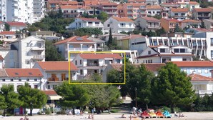 Uma área residencial costeira com edifícios, uma praia e um corpo de água.