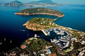 Vista aérea de uma área costeira com um porto de iates, barcos e edifícios.