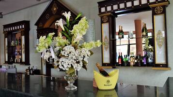 Um espaço de bar com um vaso de flores e um balde de champanhe.