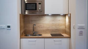 Estúdio luxo, 1 cama King, para não fumantes, cozinha americana | Cozinha americana privada | Cooktop, chaleira elétrica, talheres/pratos/utensílios de cozinha