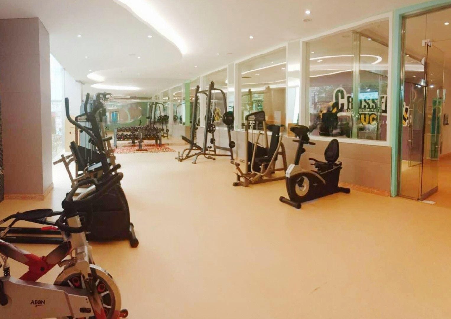Academia com diversos equipamentos de exercício, incluindo esteiras, bicicletas ergométricas e aparelhos de musculação.