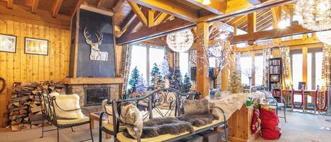 Interior acolhedor de uma cabana de madeira com lareira, paredes de madeira e um pinheiro de Natal decorado.