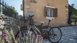 Uma bicicleta estacionada em frente a um edifício com uma parede de pedra e uma placa que diz 'Villa Giovanna'.