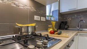 Uma cozinha moderna com fogão a gás, bancada de madeira e eletrodomésticos de aço inoxidável.
