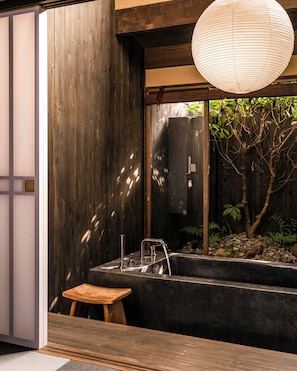 Banheira e chuveiro separados, secador de cabelo, chinelos